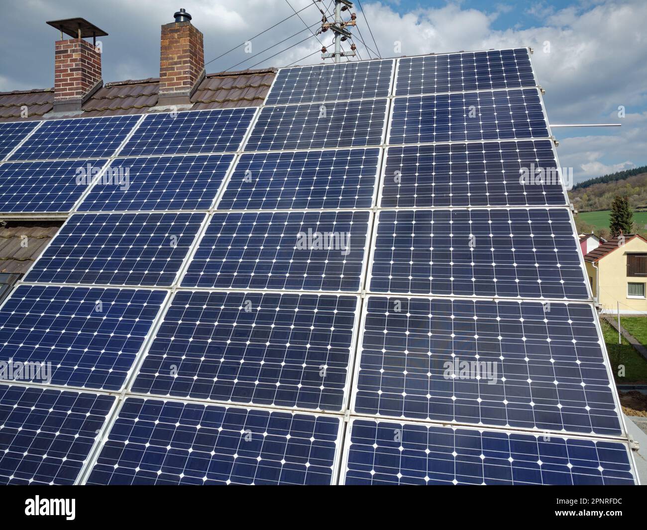 The sun shines on photovoltaic panels of older construction on a house ...