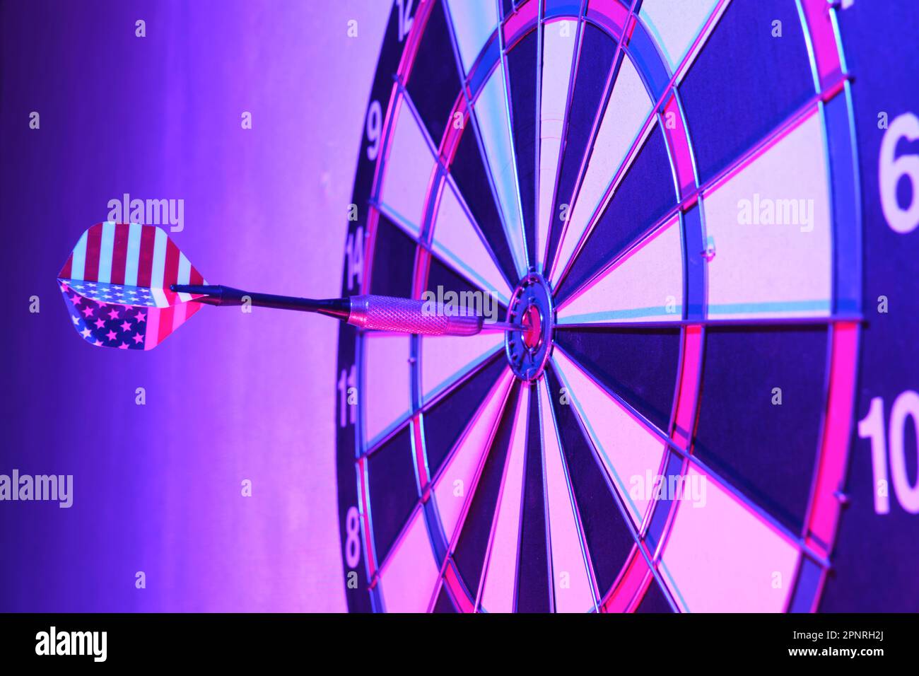 Dartboard and dart are stuck in center of board.Bright rainbow photo ...
