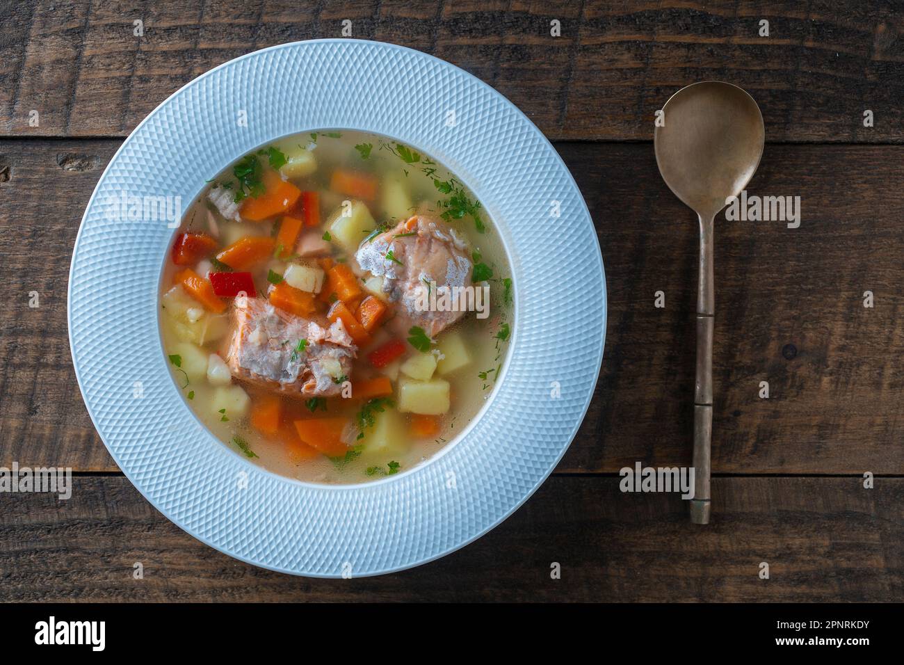 Fresh salmon fish soup with carrots, potatoes and red peppers in a ...