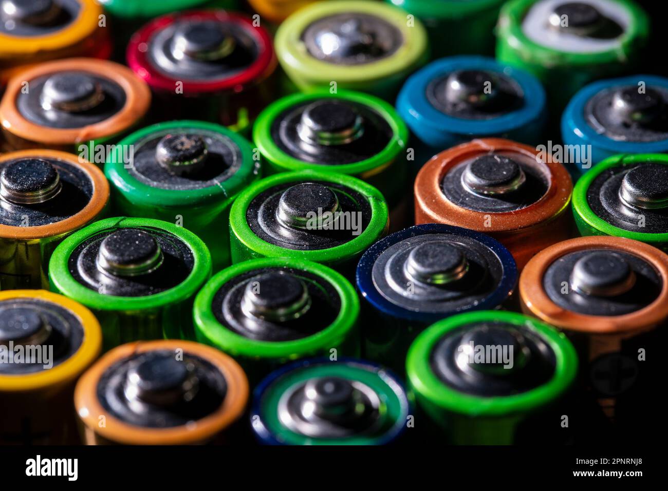 Lots of colorful discharged old batteries. Used battery on background ...