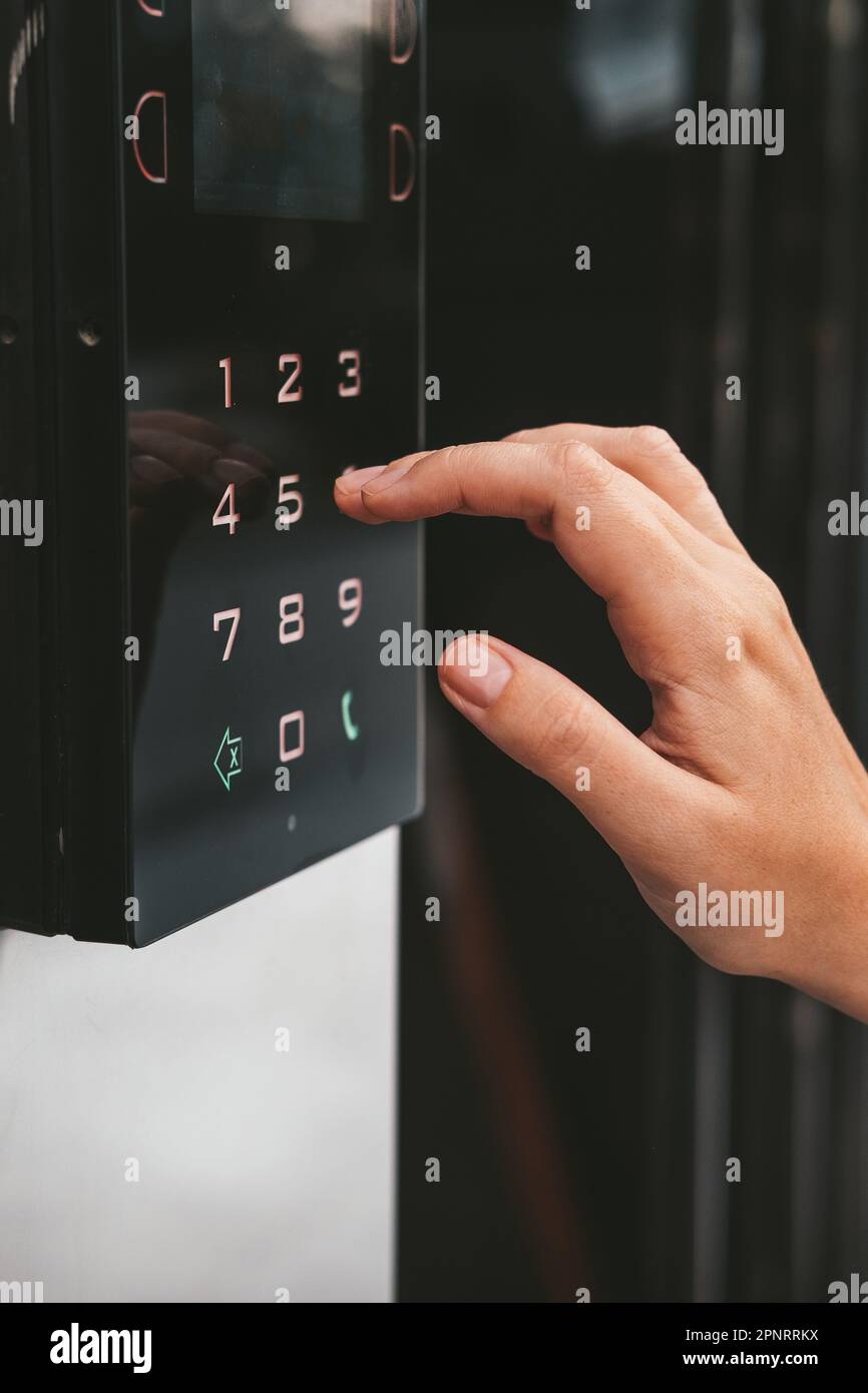 Entering a digital code on the control panel to enter the building ...