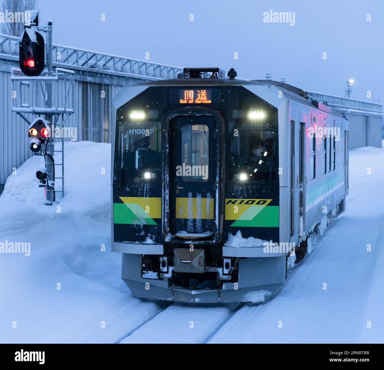 A JR Hokkaido H100 series train arrives on a snowy day at Kutchan Station in Japan Stock Photo ...