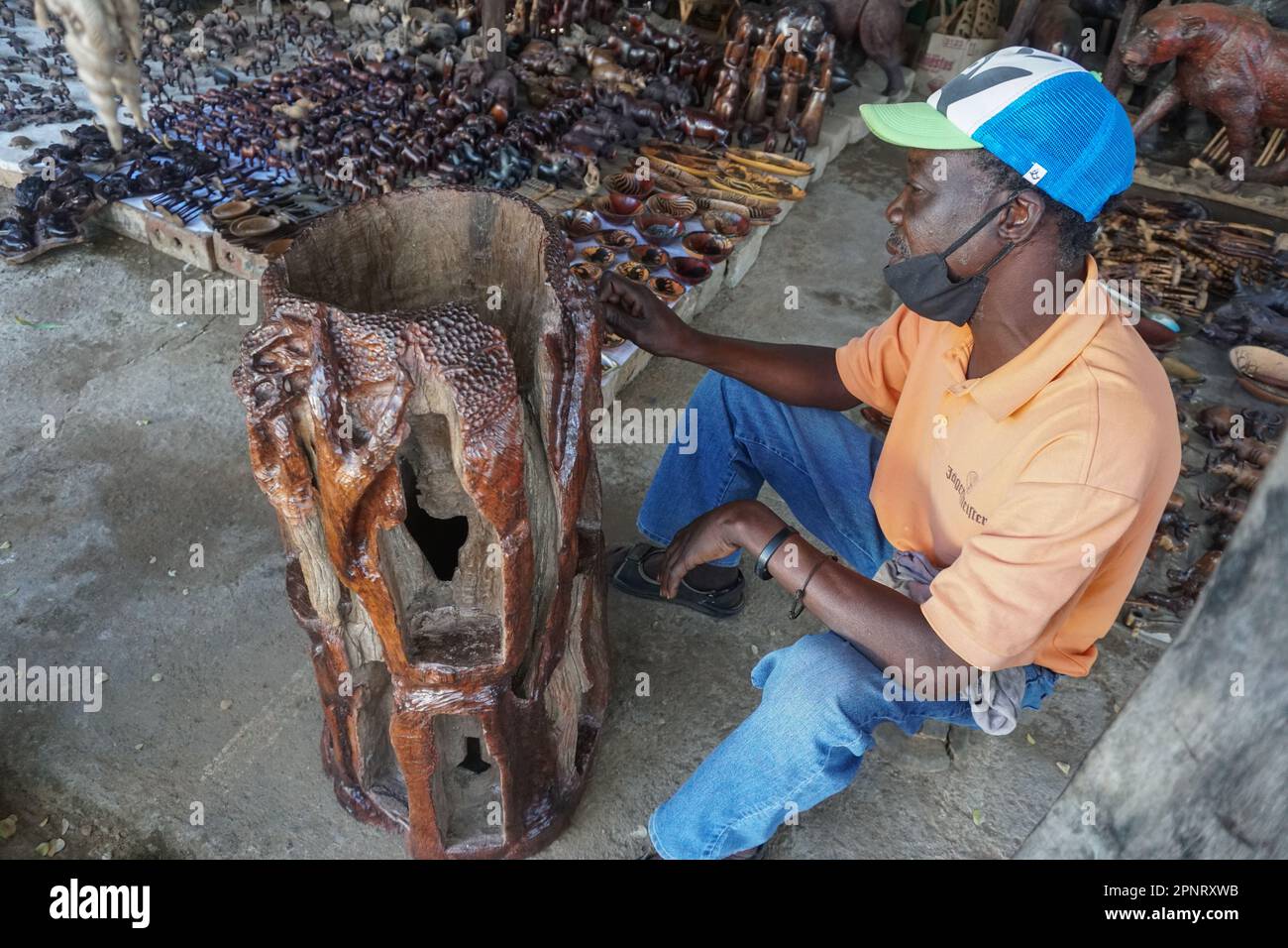 Japhet Nyoni polishes a carved wooden sculpture, which will serve as a ...