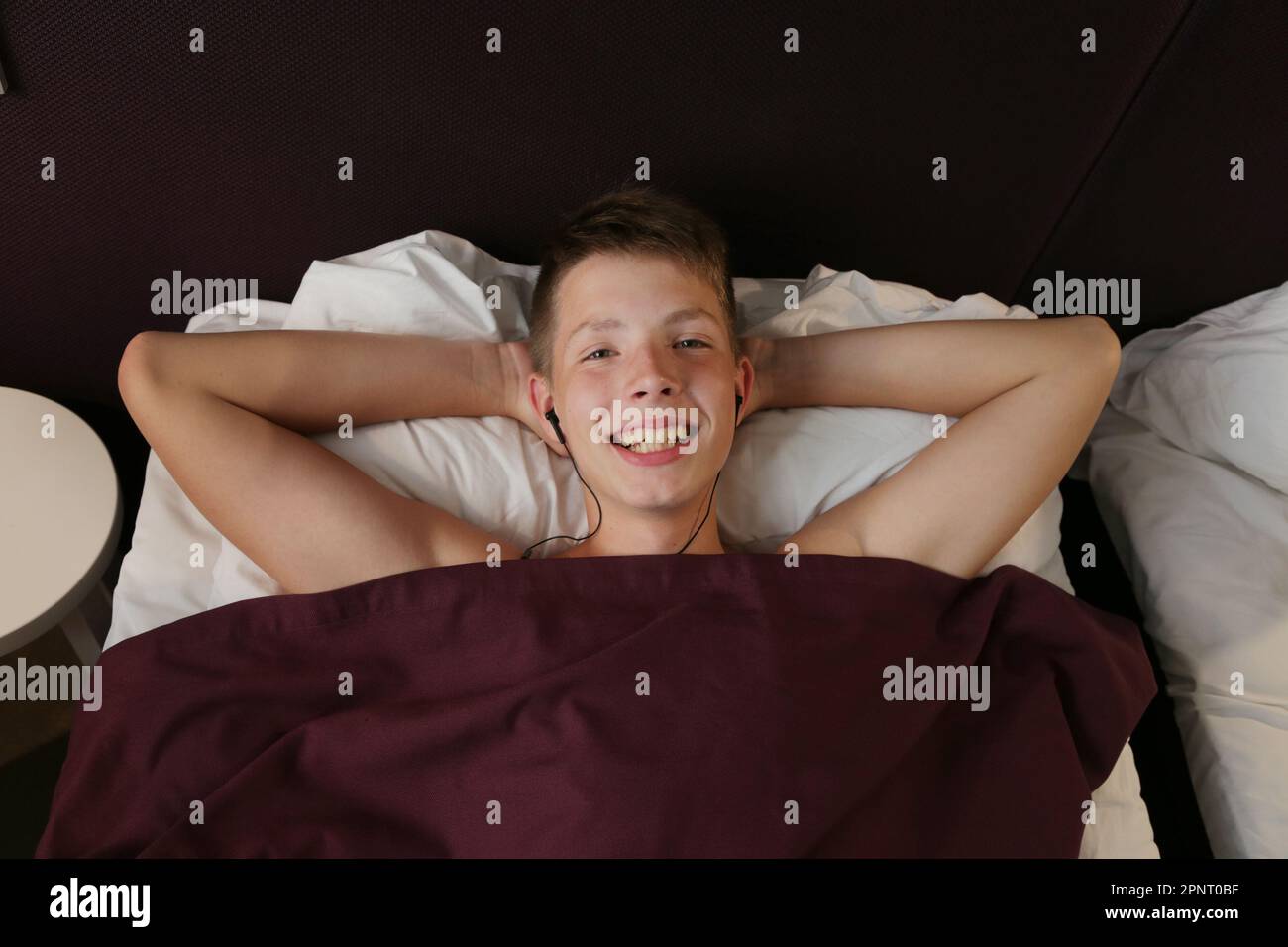 Top down view of a smiling boy in bed on a pillow Stock Photo - Alamy