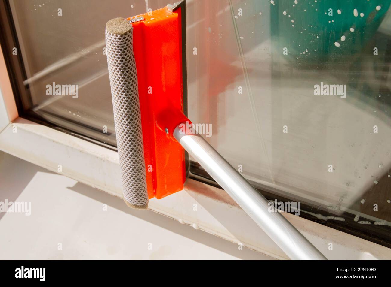 Window washing. Cleaning the window with a brush and foam. The concept ...
