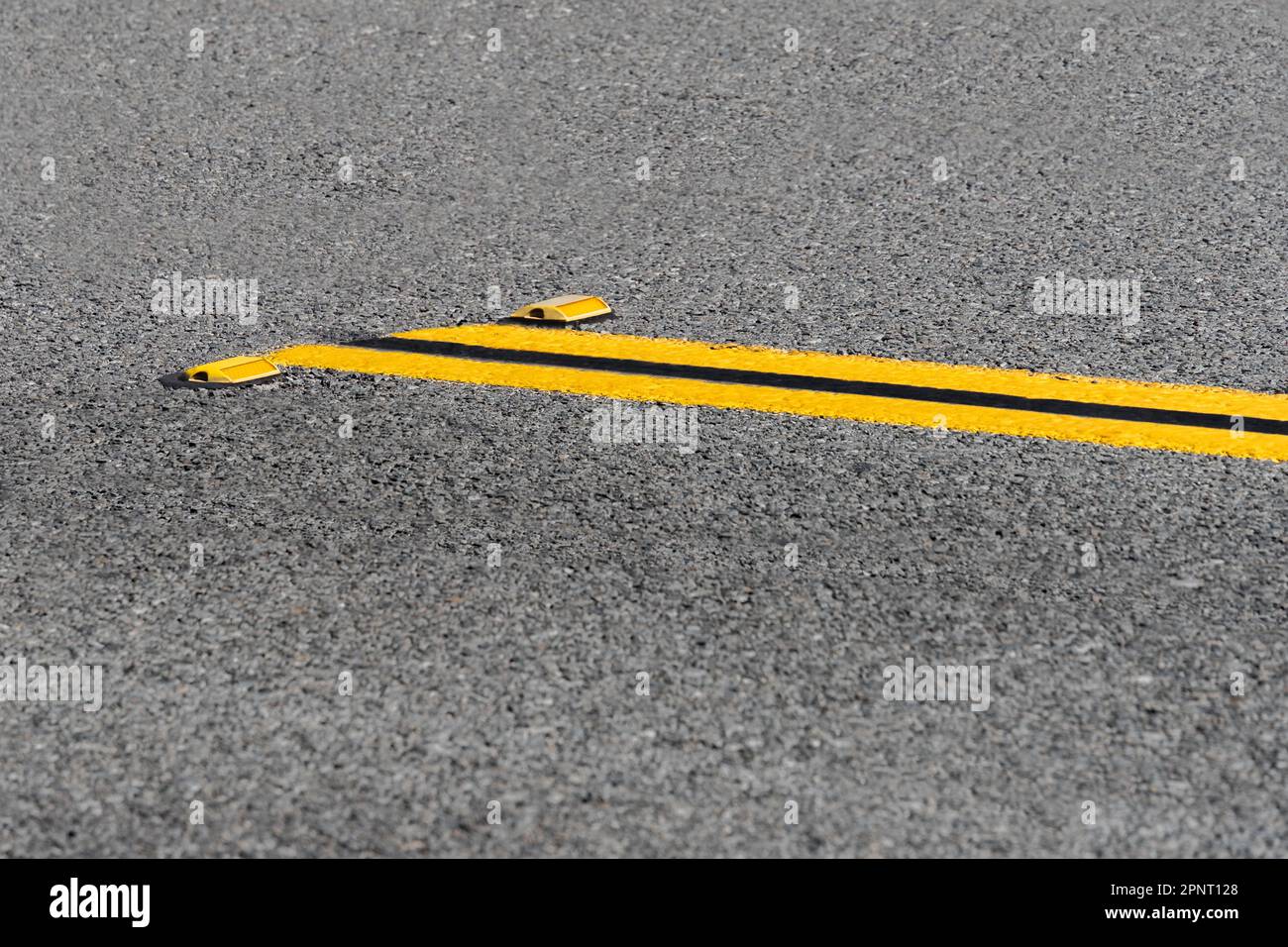 Double yellow lines on asphalt road with reflectors Stock Photo - Alamy