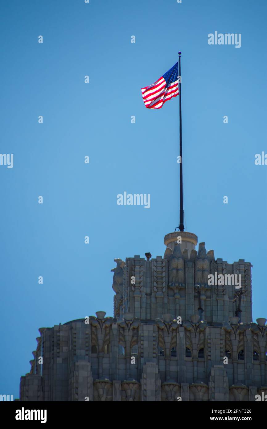 n American Flag is flying in the wind on top of a flag pole. The pole ...