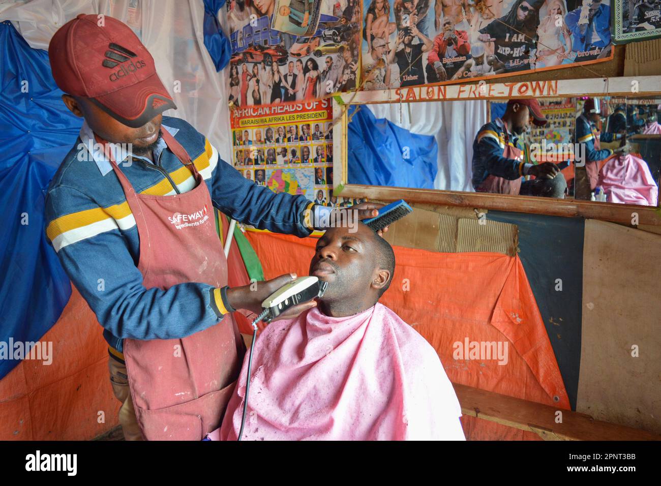 Justin Paluku Mukule trims Ramazani Ghislain’s beard at a salon located ...