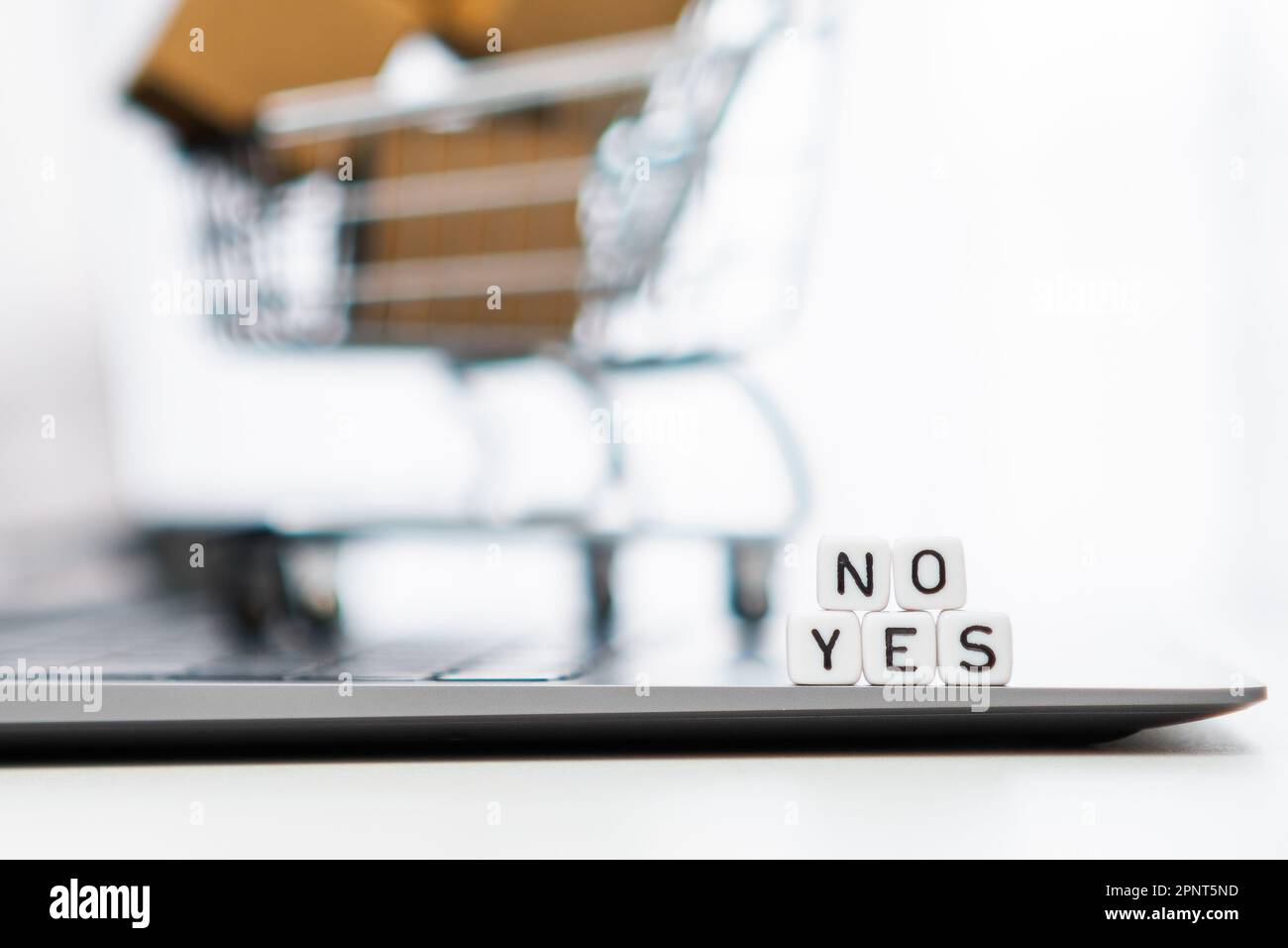 Yes or no words on cubes with a toy shopping cart and cardboard boxes ...