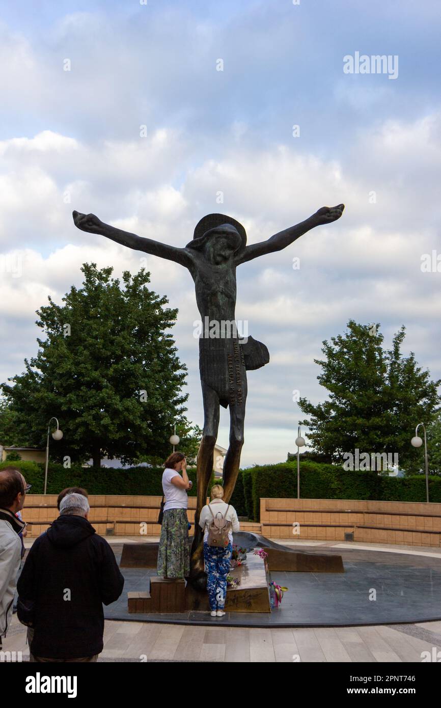 People venerating the statue of the Risen Christ in Medjugorje. The ...