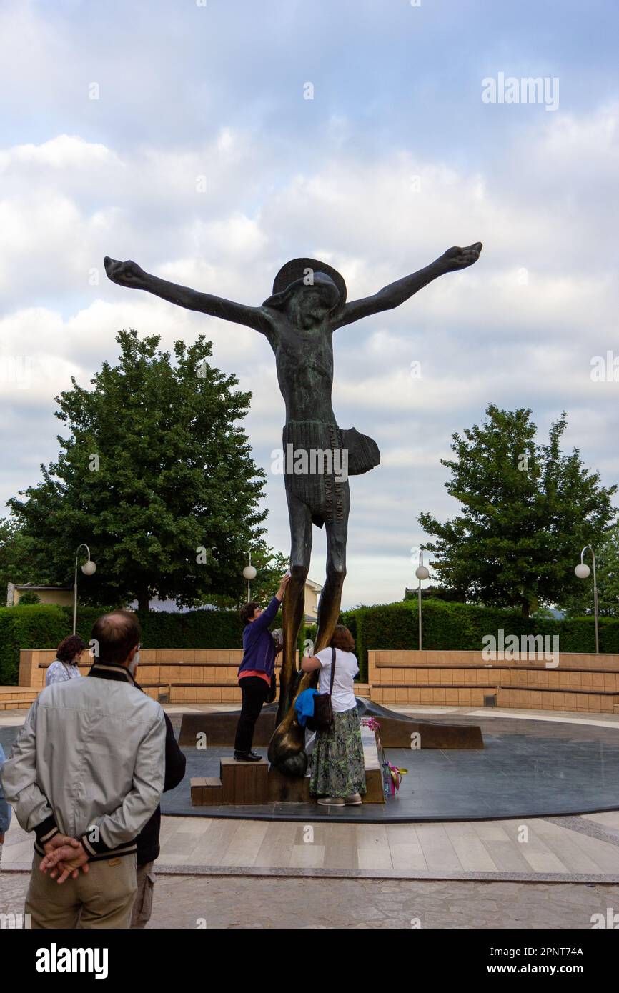 People venerating the statue of the Risen Christ in Medjugorje. The ...
