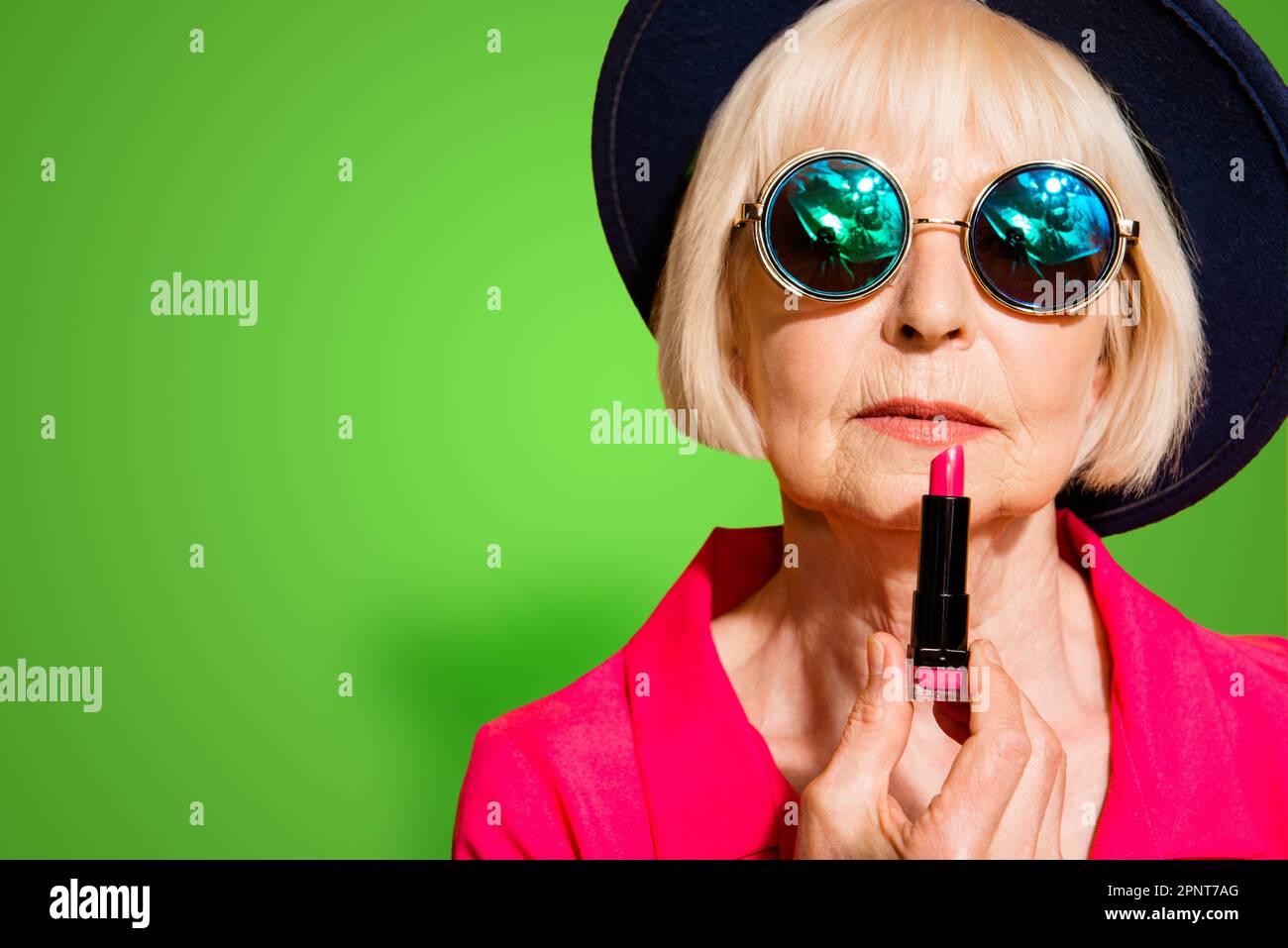 Makeup Time Granny colors the lips holding red lipstick isolated on ...