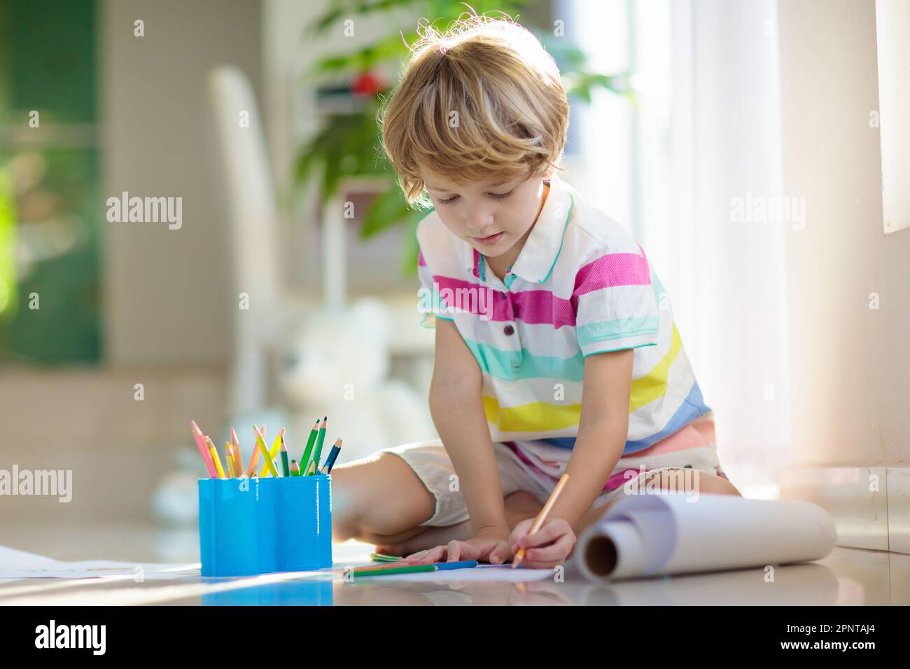 Child drawing lying on the floor. Kid painting rainbow. Online remote ...