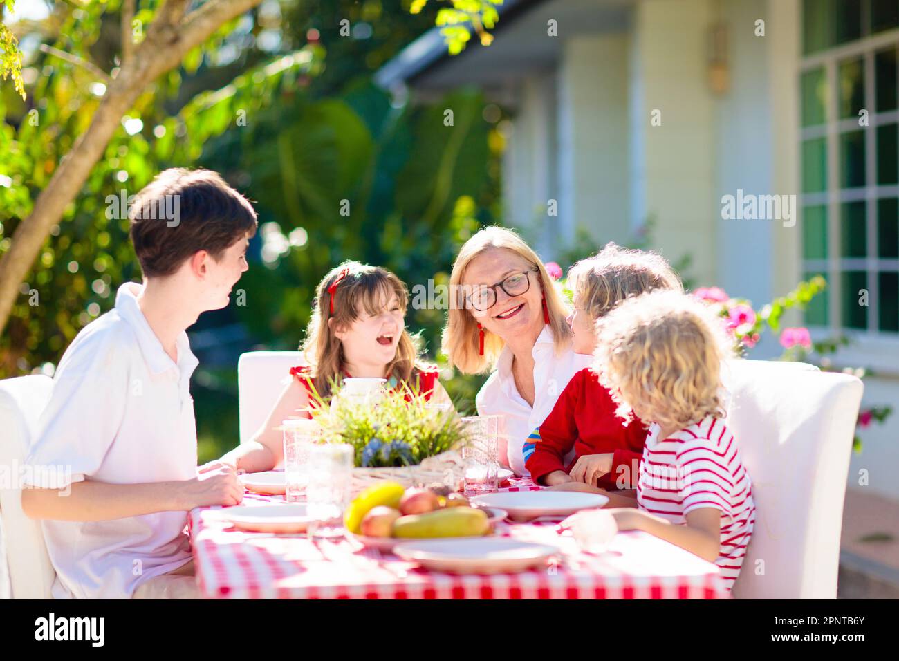 Family eating outdoors. Garden summer fun. Barbecue in sunny backyard ...