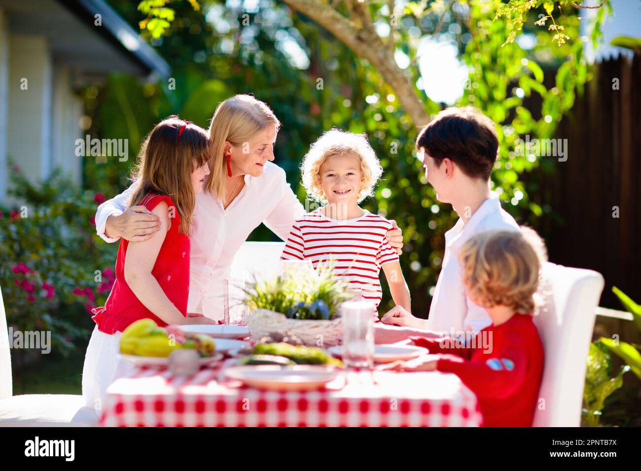 Family eating outdoors. Garden summer fun. Barbecue in sunny backyard ...