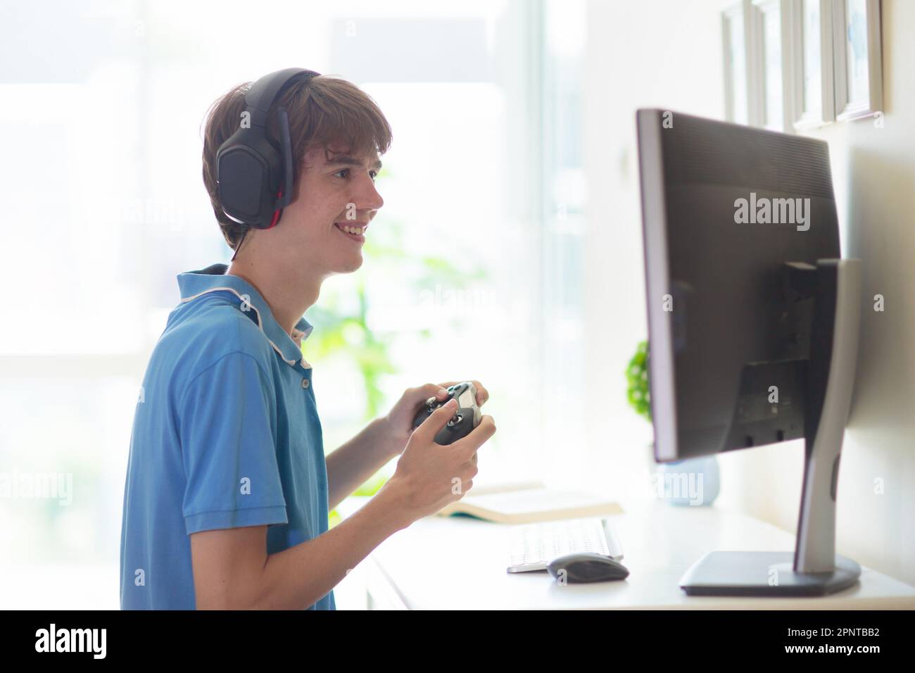 Teenager working on computer. Student with laptop doing homework or ...