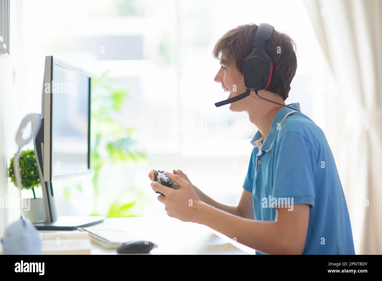 Teenager working on computer. Student with laptop doing homework or ...