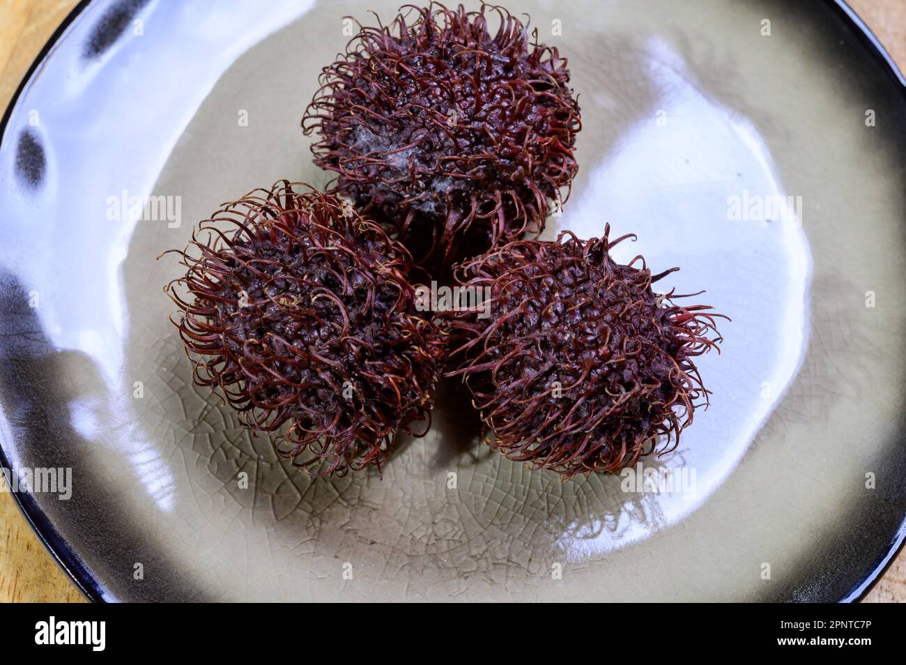 Tasty tropical exotic fruits, sweet ripe fresh unpeeled hairy rambutan ...