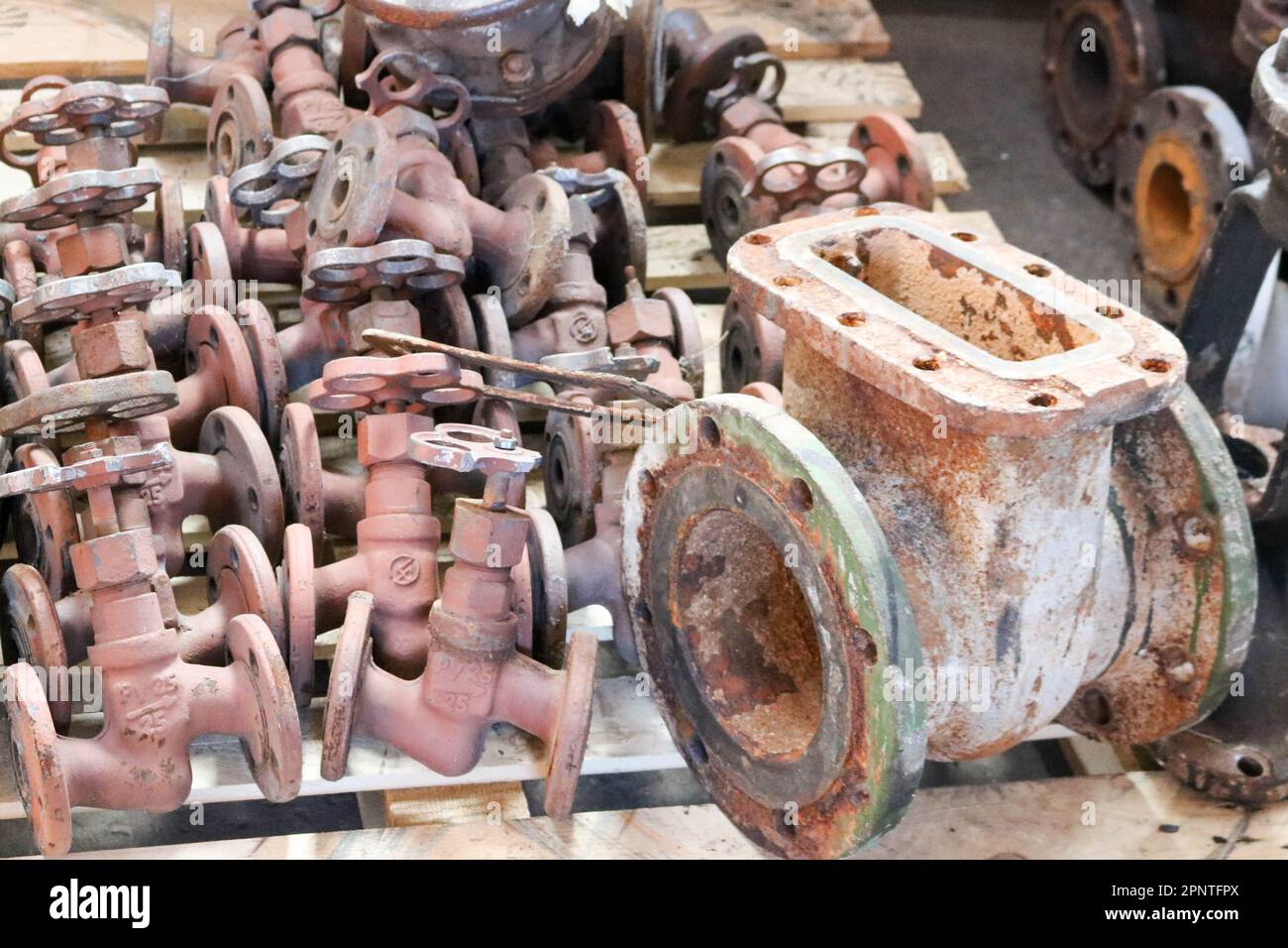 Large rusty old metal gate valve, pipe fittings, against the background ...