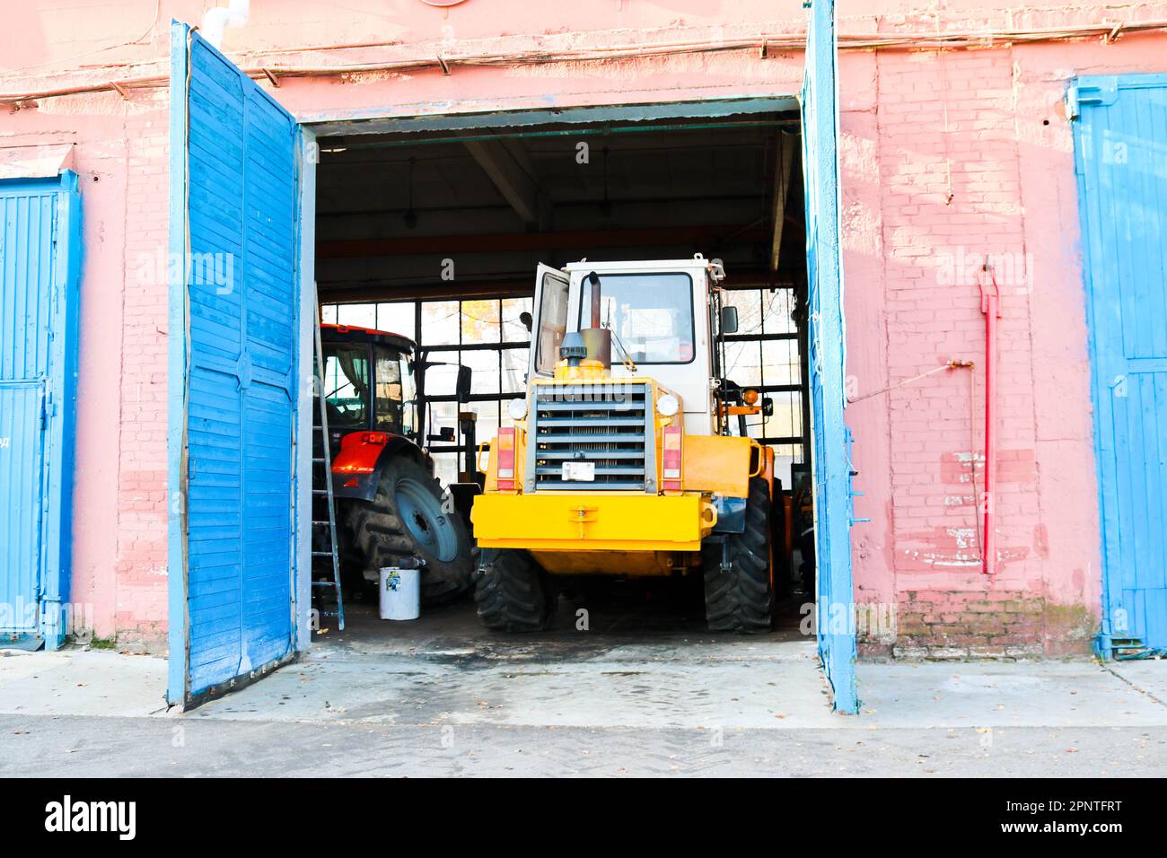 Large powerful yellow tractor with large wheels in the hangar ...