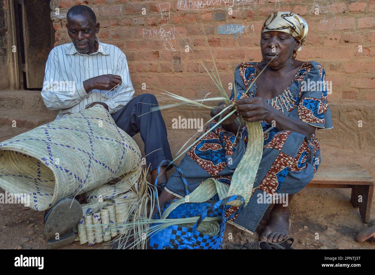 Eliya Muhindo Ndekivuya, left, and his wife, Kavira Vyerire, weave mats ...