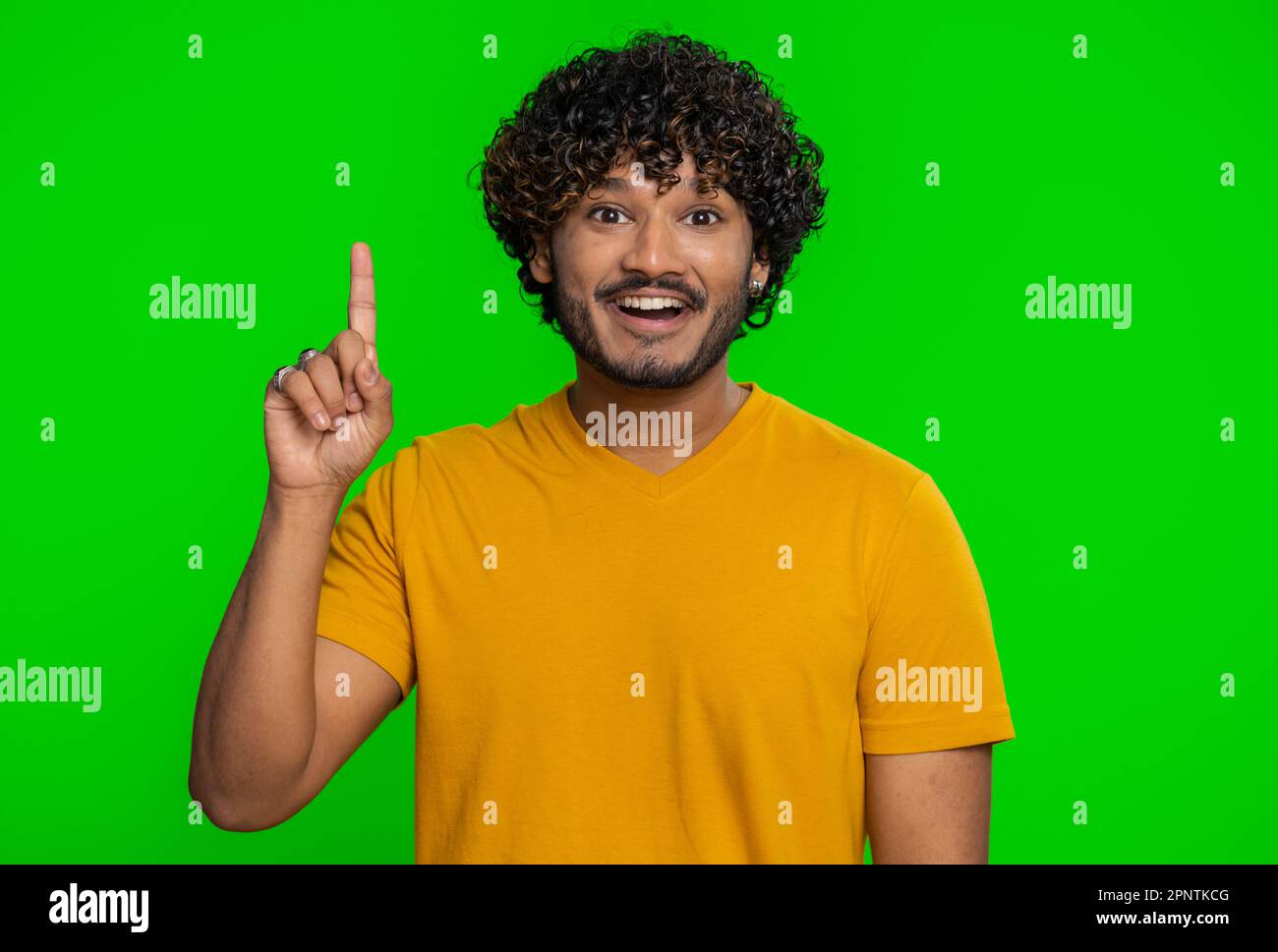 Eureka. Inspired young indian man pointing finger up with open mouth ...