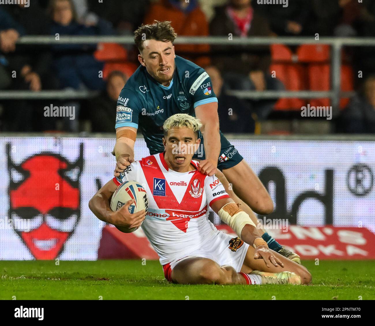 Tee Ritson #25 of St Helens is tackled by Matty Ashton #5 of Warrington ...