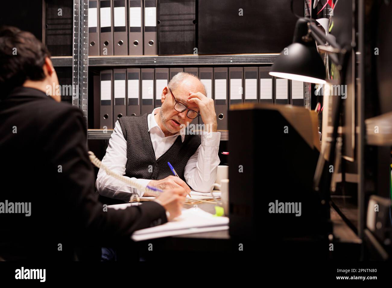 Senior police officer analyzing crime scene evidence in arhive room ...