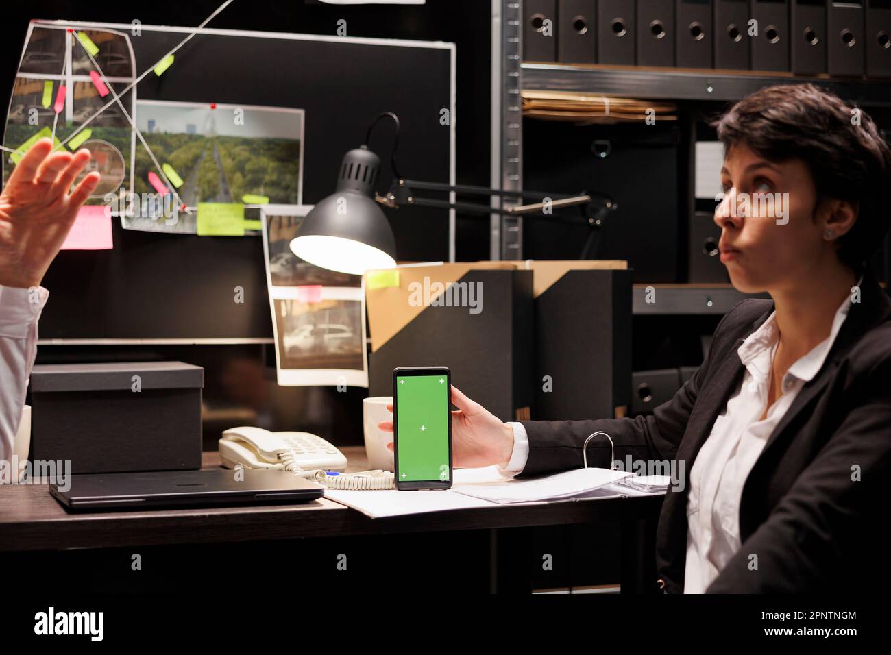 Police officers holding mobile phone with green screen mock up display ...