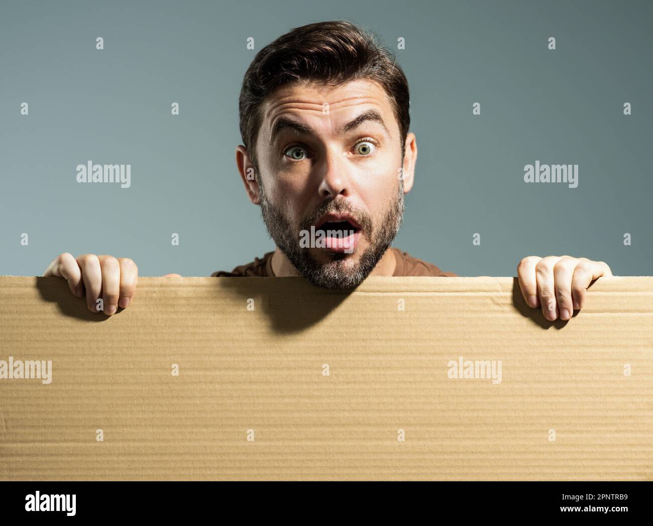 Surprised man holds the white sign, blank card. Placard ready for your ...