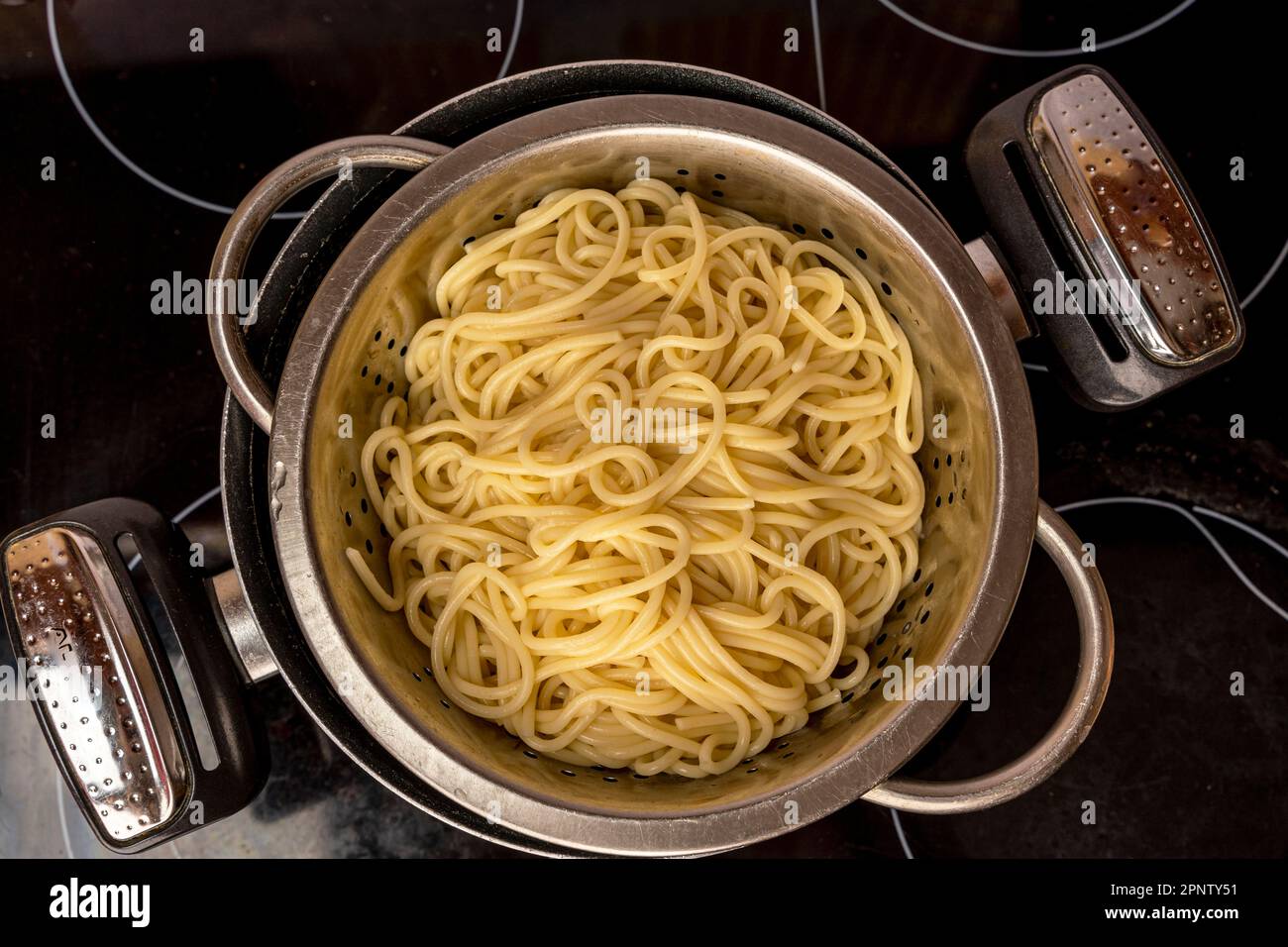 boiled ready-made spaghetti toss in a colander. view from above Stock ...