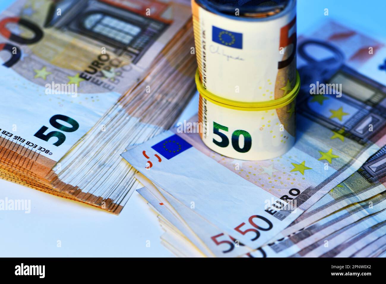 Concept of many euros: a pile of rolled 50-euro bills lying on a white ...