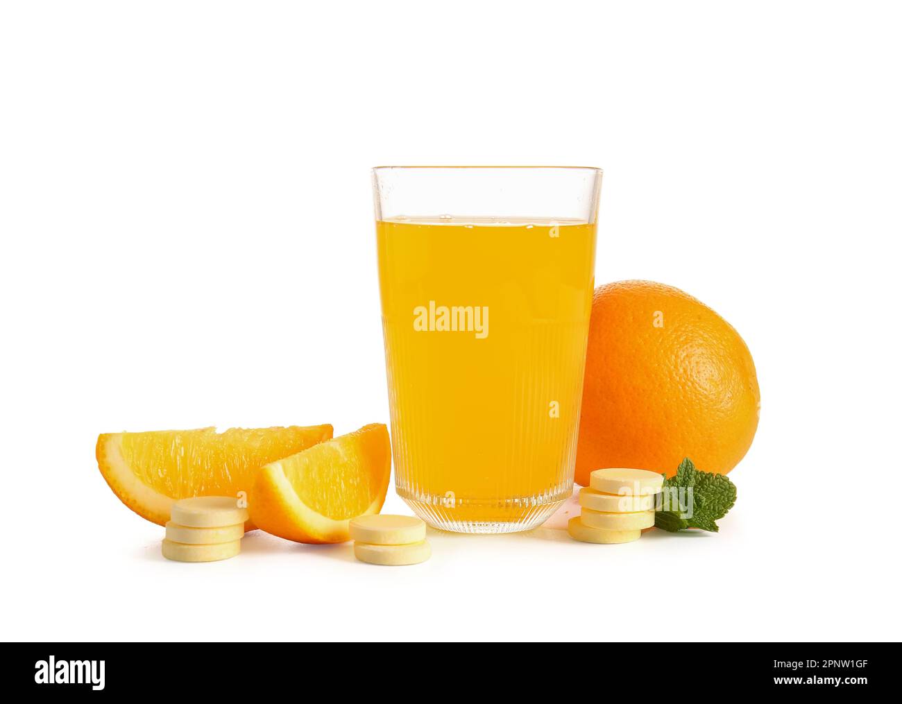 Glass of vitamin C effervescent tablet dissolved in water and oranges ...