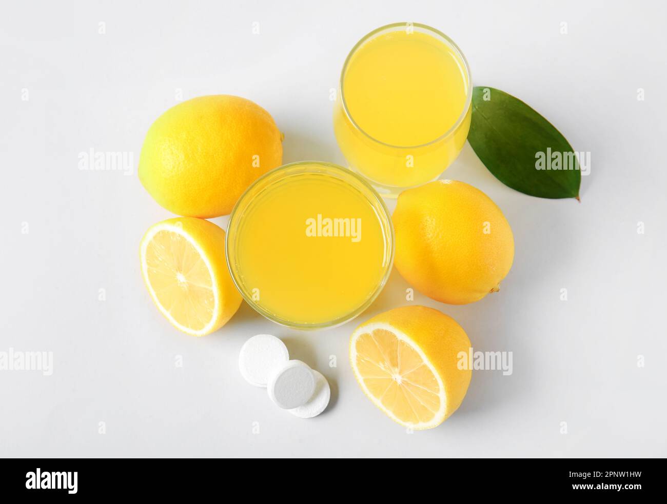 Glass of vitamin C effervescent tablet dissolved in water and lemons on ...