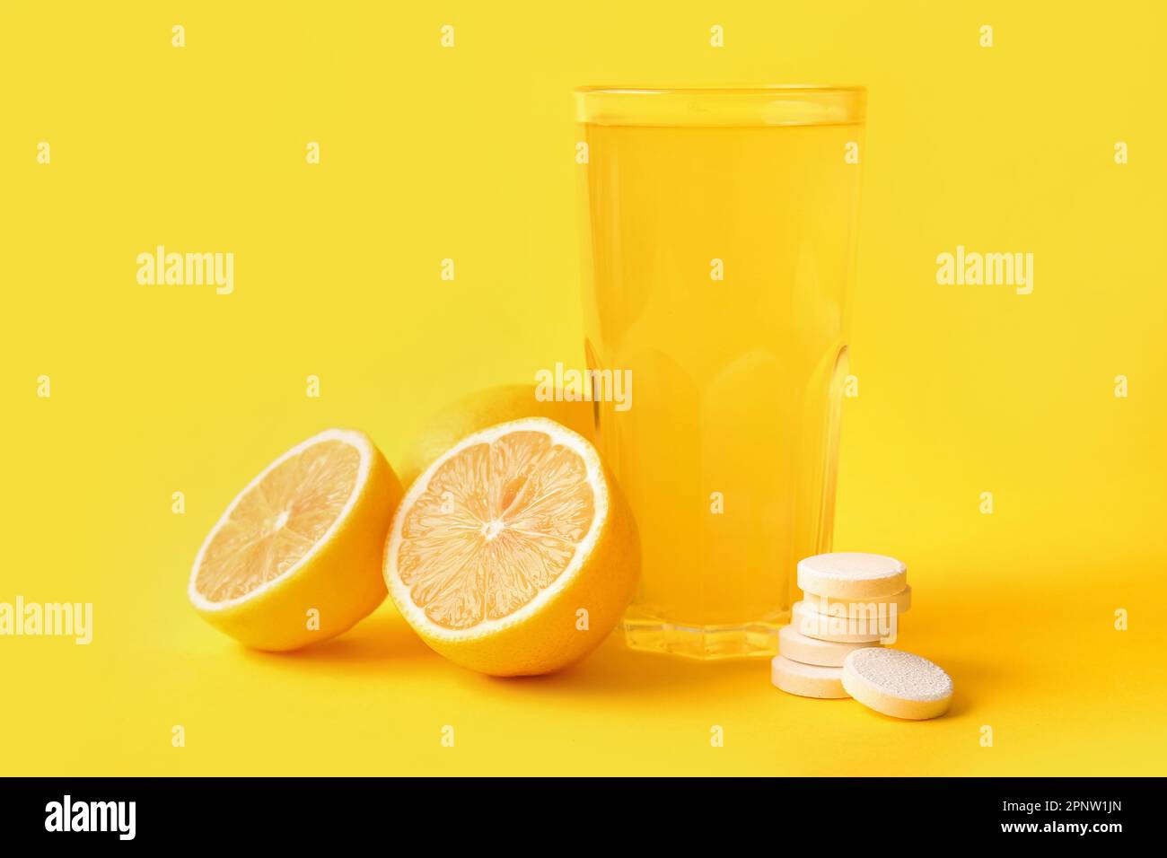 Glass of vitamin C effervescent tablet dissolved in water and lemons on ...