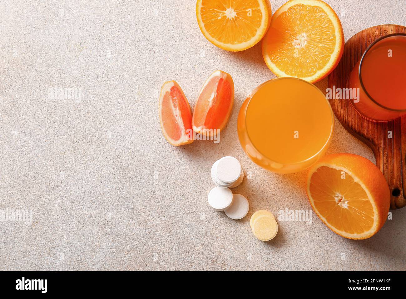 Glasses of vitamin C effervescent tablet dissolved in water and fruits ...