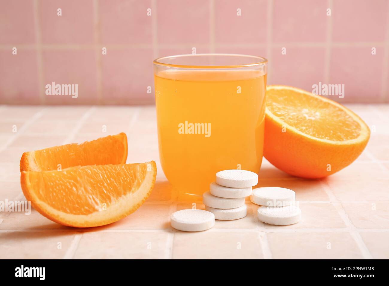 Glass of vitamin C effervescent tablet dissolved in water and orange on ...