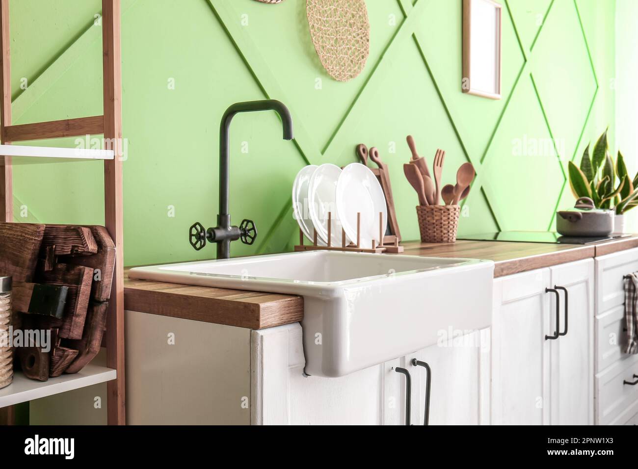 Kitchen counters with sink near green wall Stock Photo - Alamy