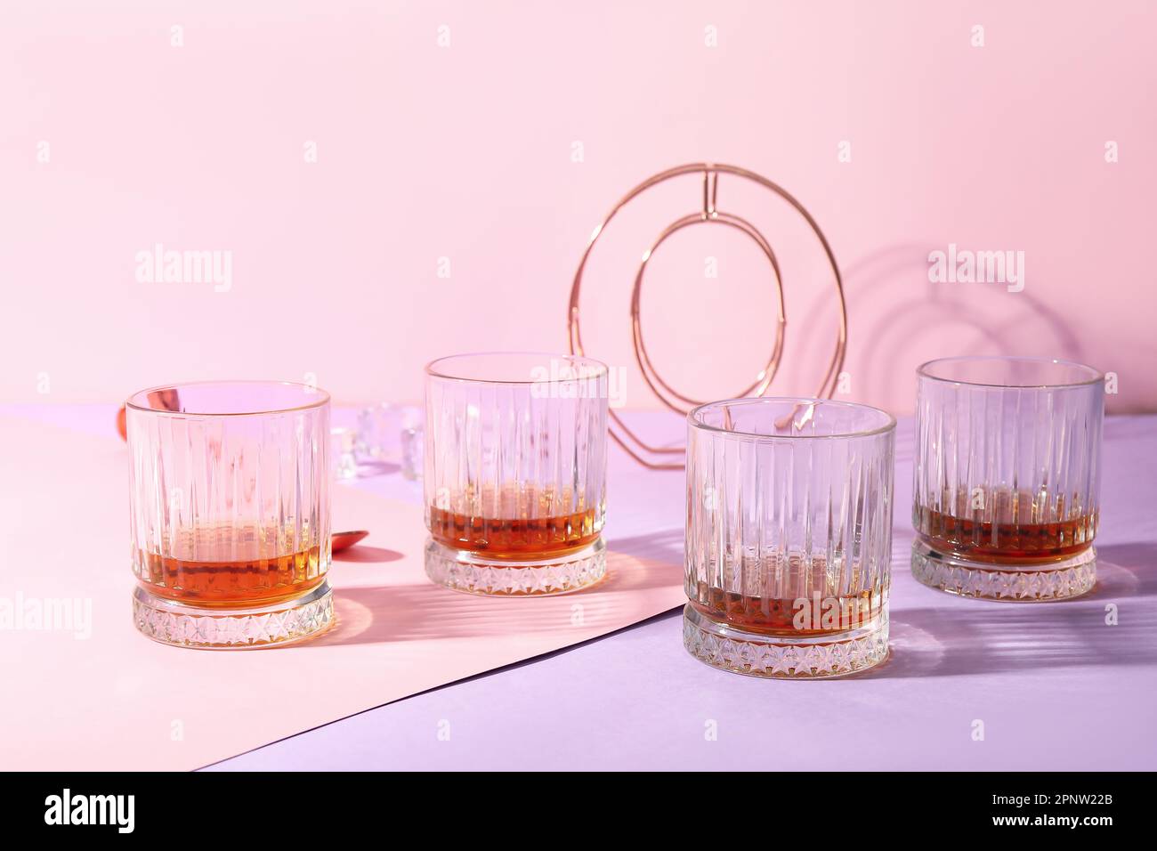 Glasses of rum on pink and lilac background Stock Photo - Alamy