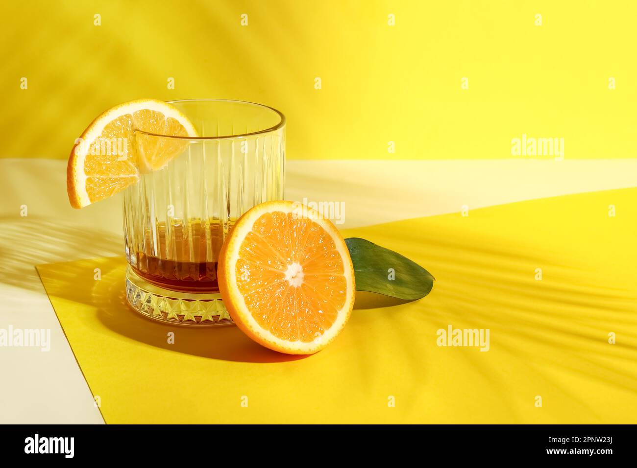 Glass of rum with orange slice on yellow background Stock Photo - Alamy