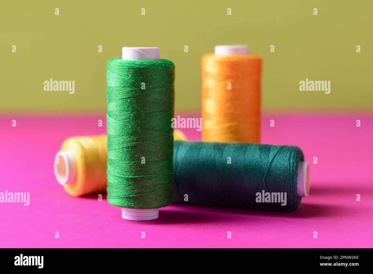 Set of different sewing threads on color table Stock Photo - Alamy