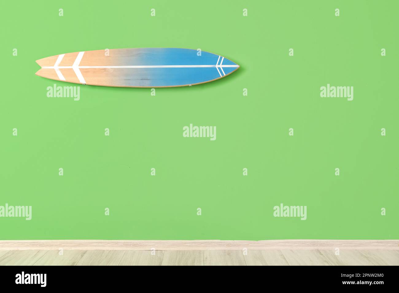 Wooden surfboard hanging on green wall in room Stock Photo - Alamy