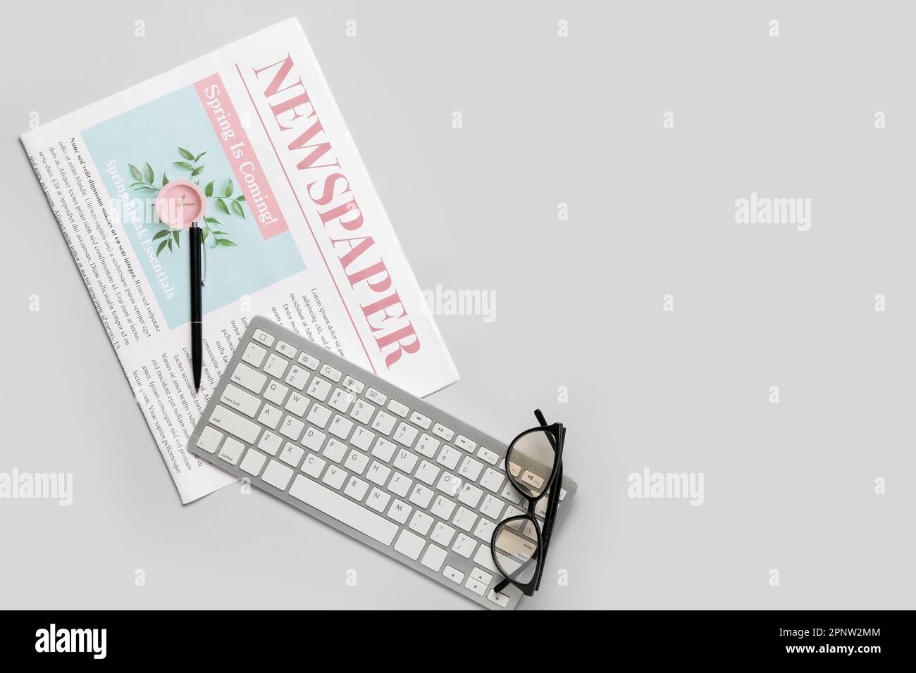 Newspaper with pen, computer keyboard and eyeglasses on light ...