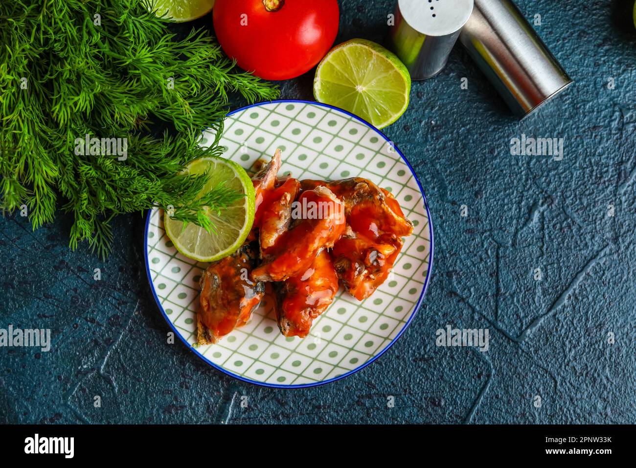 Plate with canned fish in tomato sauce on dark table Stock Photo - Alamy