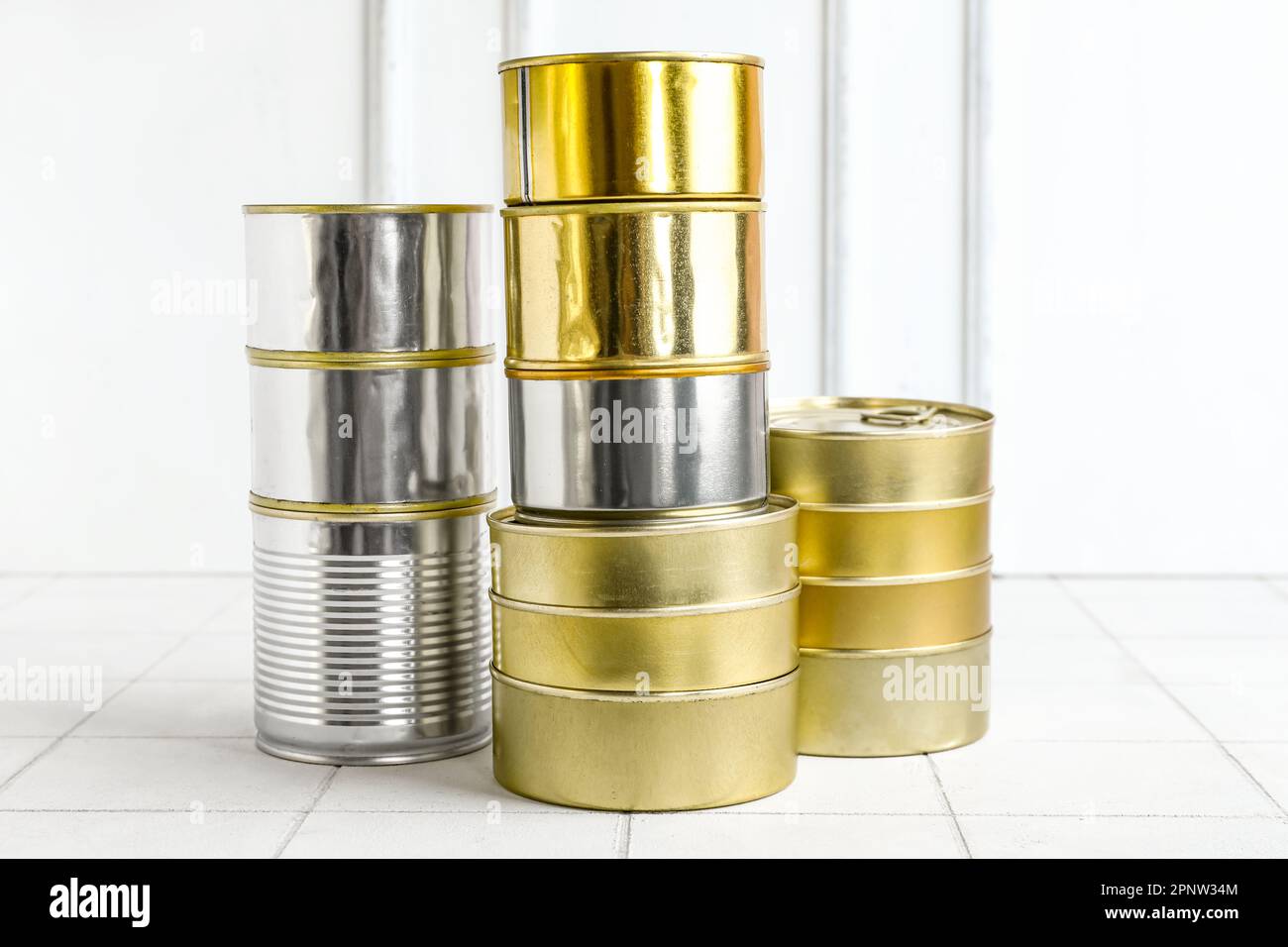 Stacks of tin cans with fish on white tiled table Stock Photo - Alamy