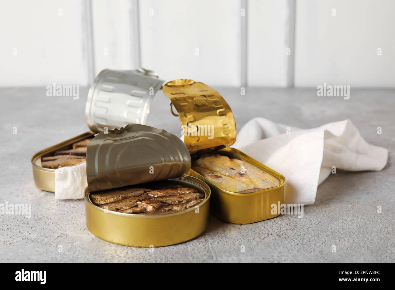 Opened tin cans with different fish on grey table Stock Photo - Alamy