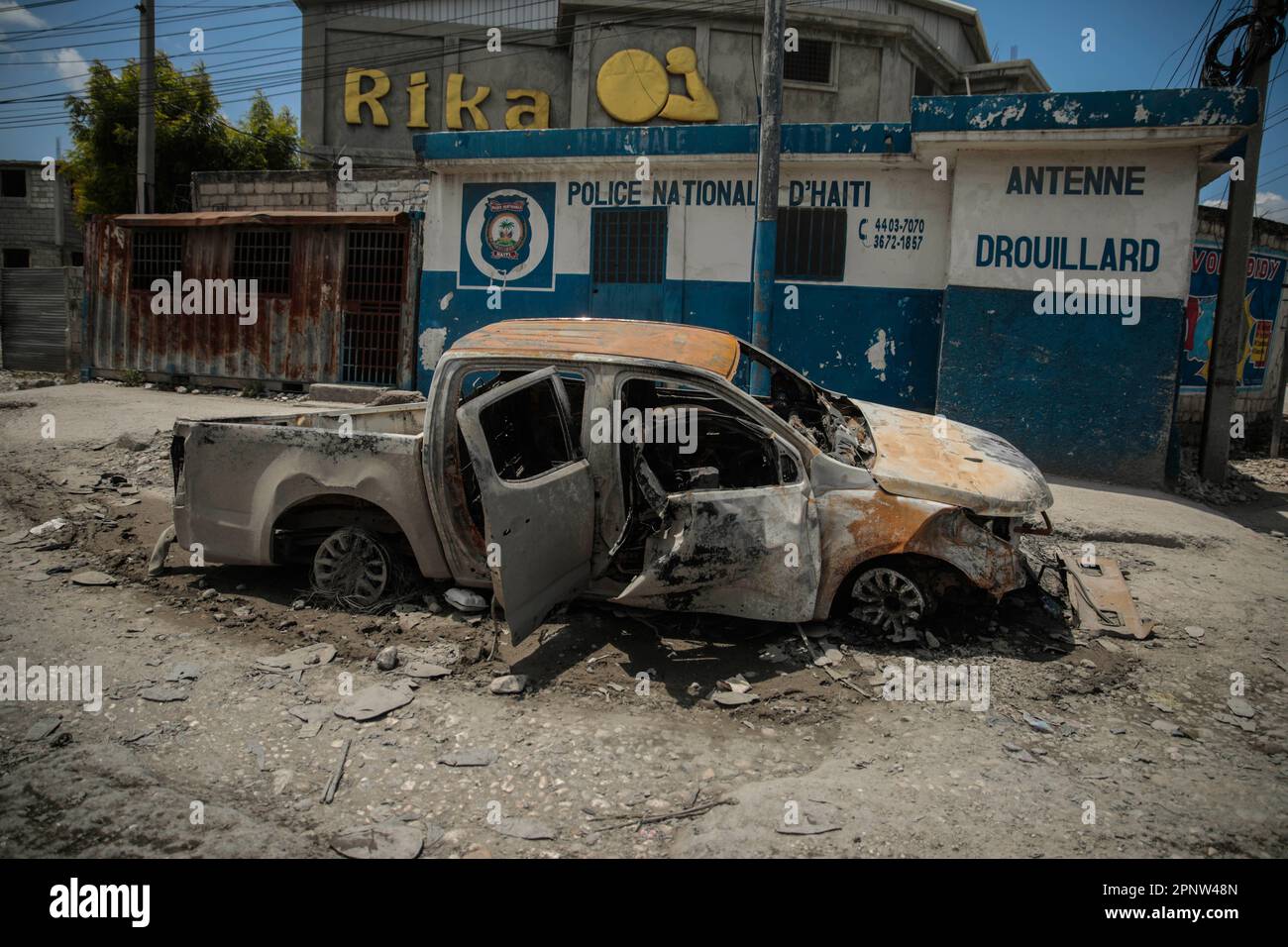The shell of a charred police car, set on fire by gang members, sits in ...