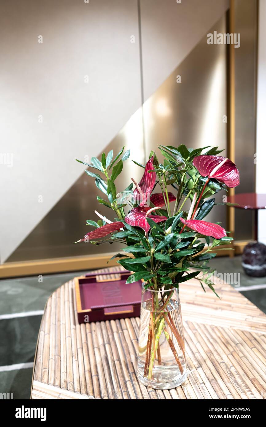 A bouquet of artificial Anthurium flowers in a transparent vase on the ...