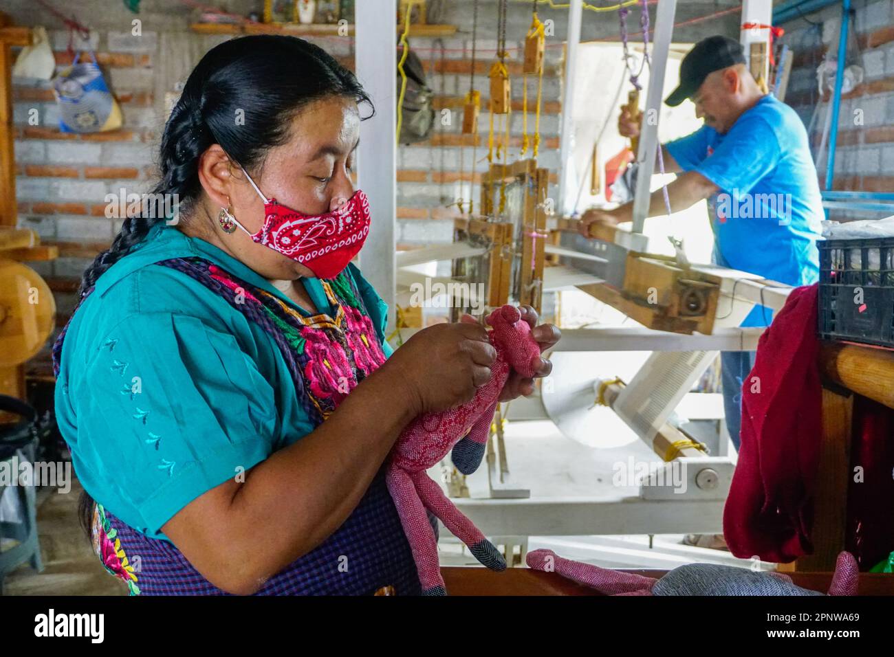 Isabel Curiel, left, sews dolls with fabrics weaved by her husband ...