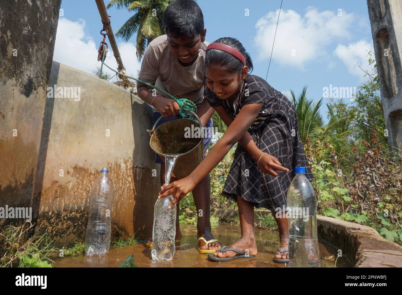 Ajanthan Jebanesan, 14, left, and Daksiya Jebanesan, 11, collect water ...